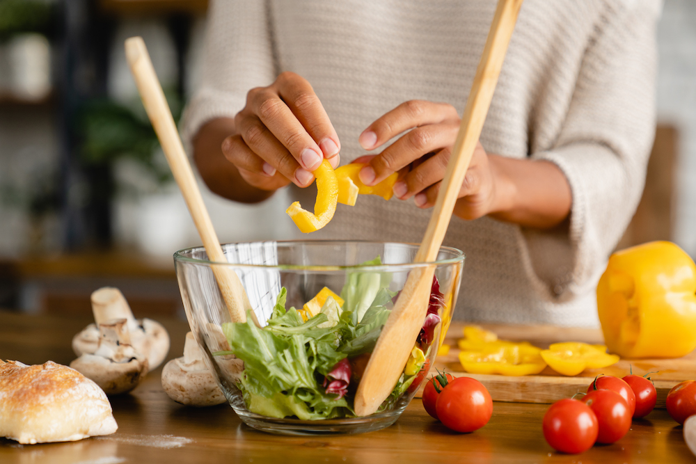 Closeup cropped shot of woman`s hands making vegetable salad, cutting ...